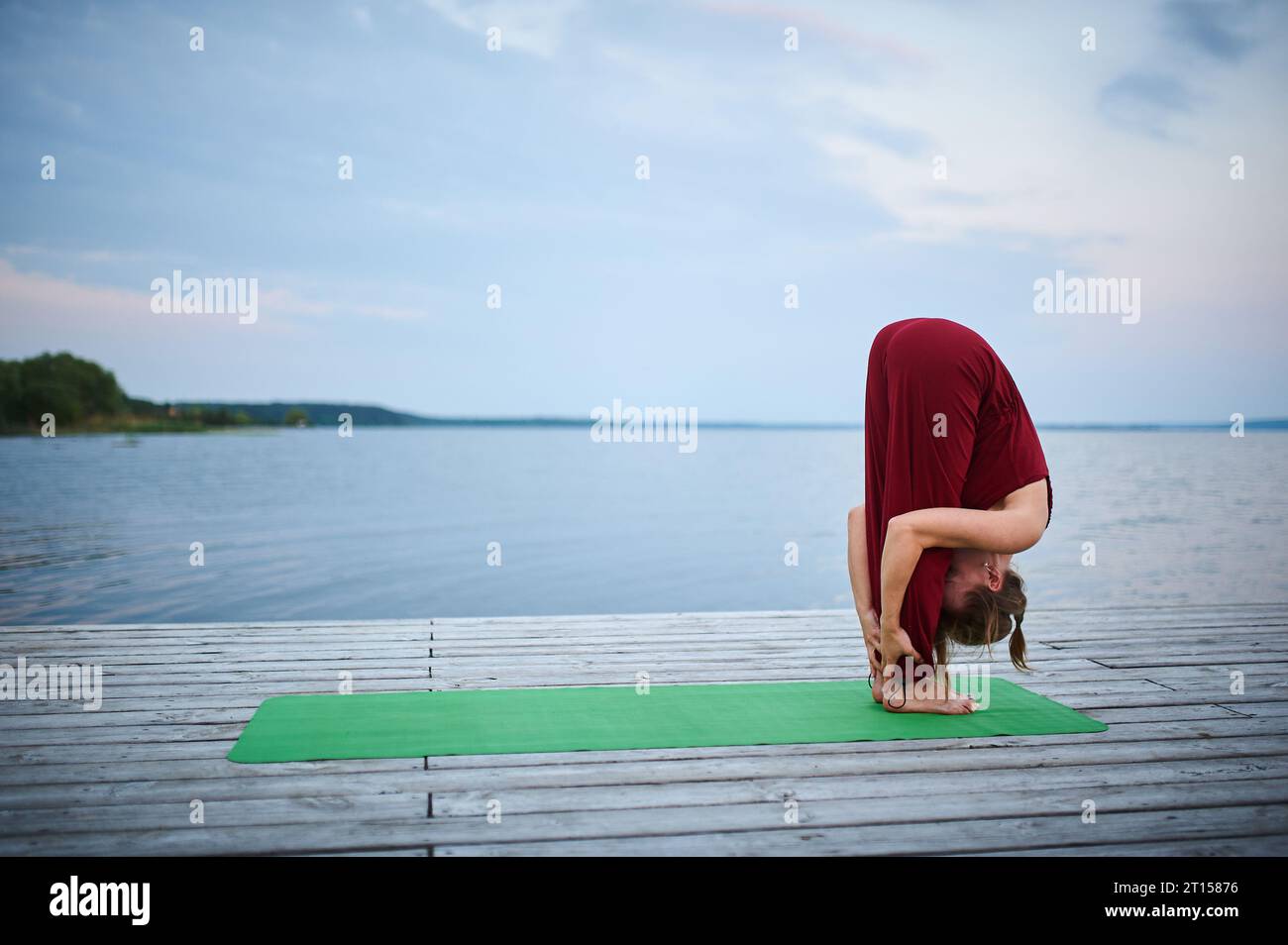 Beautiful young woman practices yoga asana Uttanasana - Standing ...