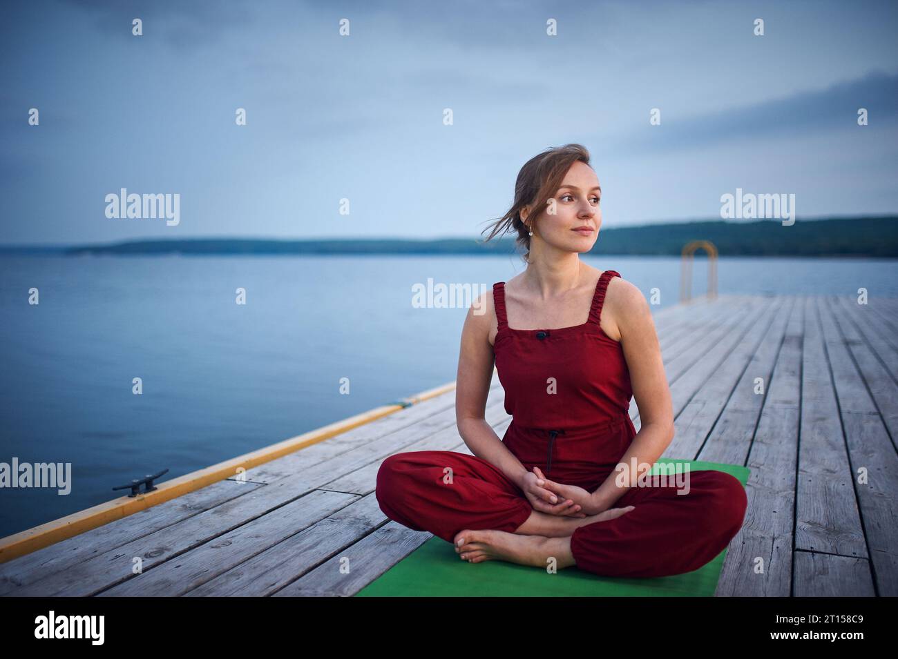 Beautiful young woman practices yoga asana Padmasana - Lotus pose on ...