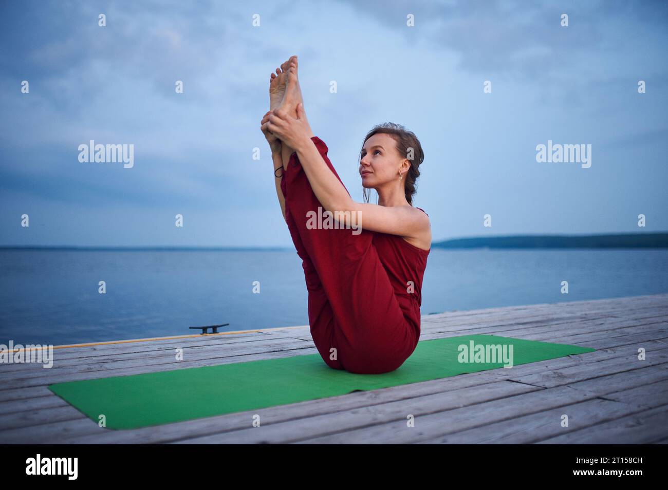 Beautiful young woman practices yoga asana Paripurna Navasana Pose on ...