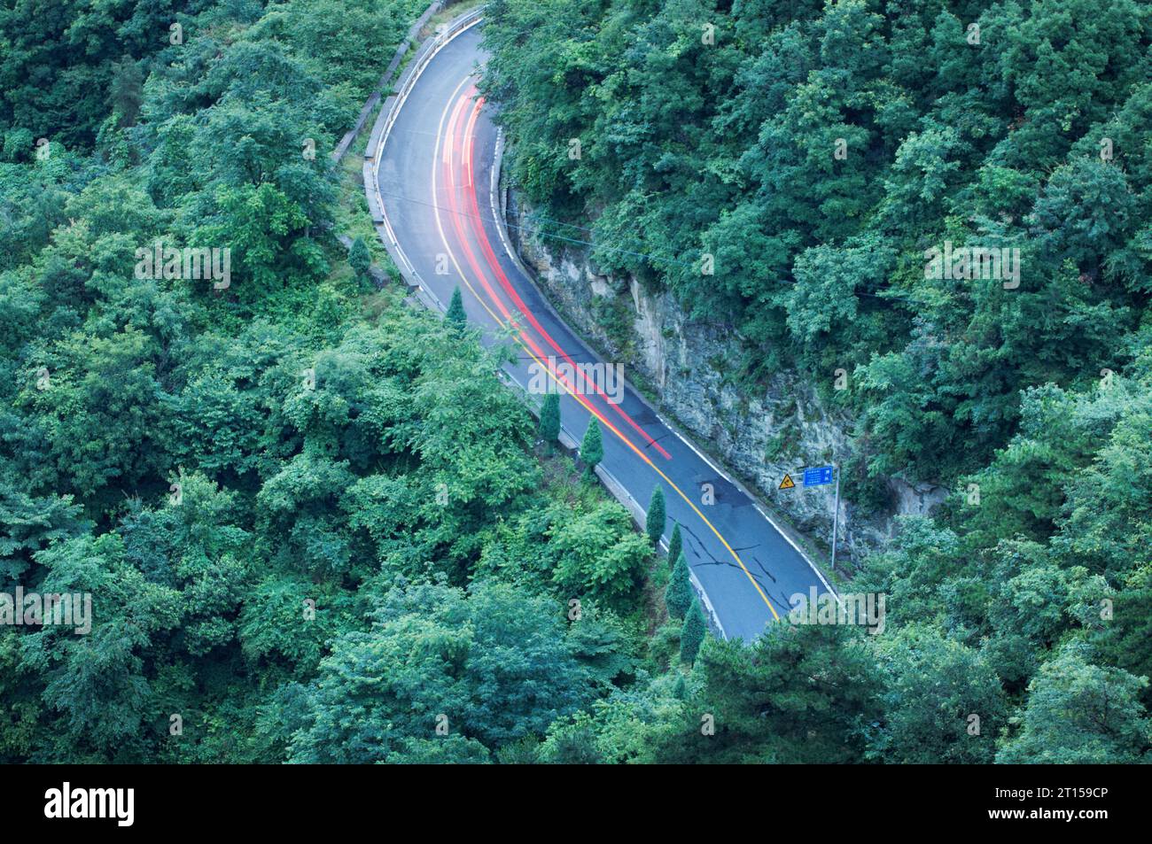 Curved road trough the forest at sunset. Aerial view Stock Photo - Alamy