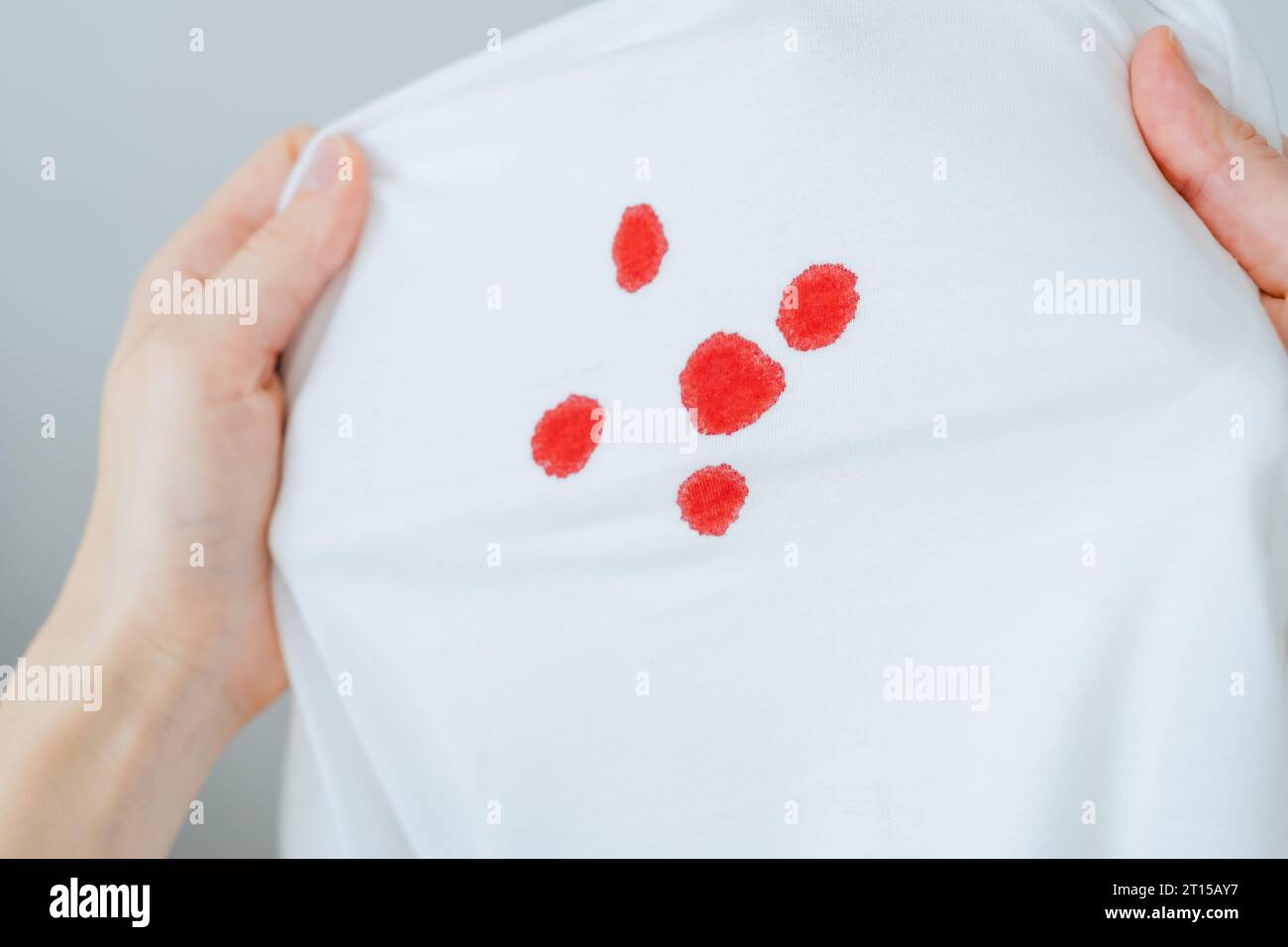 Female hands showing dirty drops blood stain on white cloth. Spoiled ...