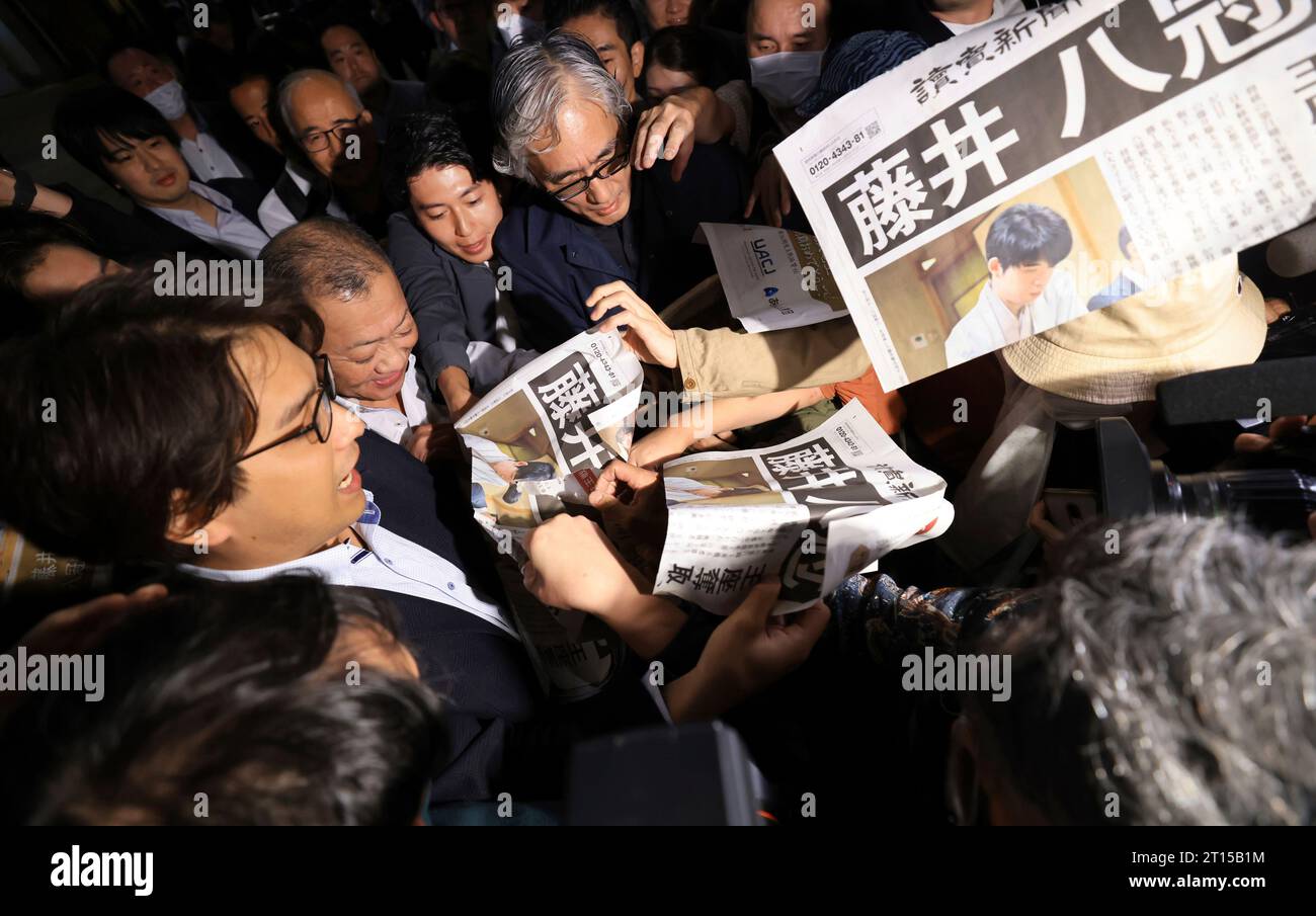 Passers-by pick up an extra edition of the Yomiuri Shimbun reporting ...