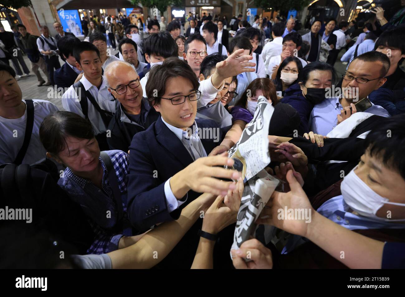 Passers-by pick up an extra edition of the Yomiuri Shimbun reporting ...