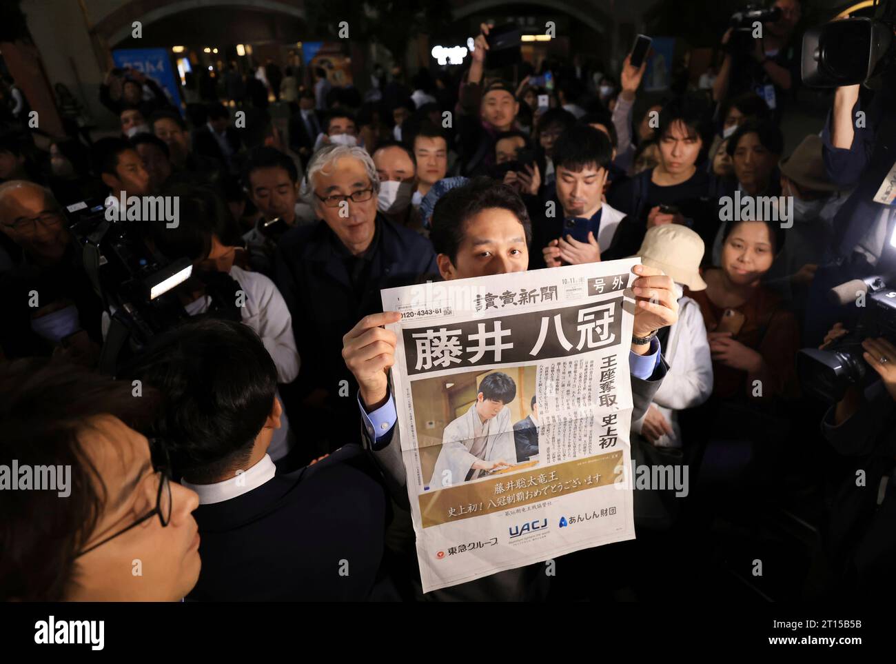 Passers-by pick up an extra edition of the Yomiuri Shimbun reporting ...
