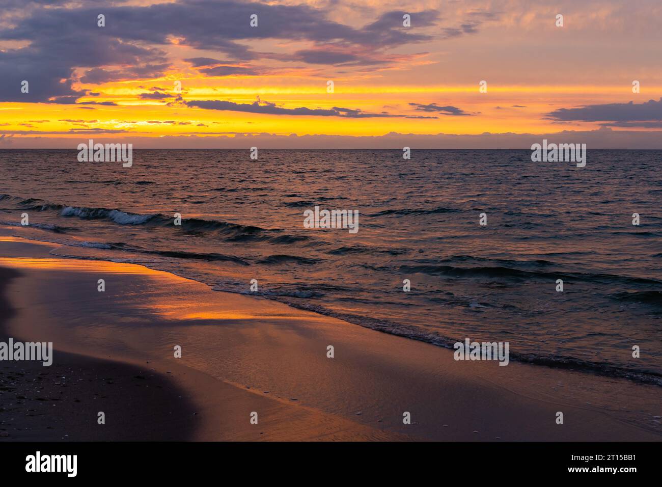 Orange sunset over the sea. Waves crashing onto the beach, dramatic sky ...