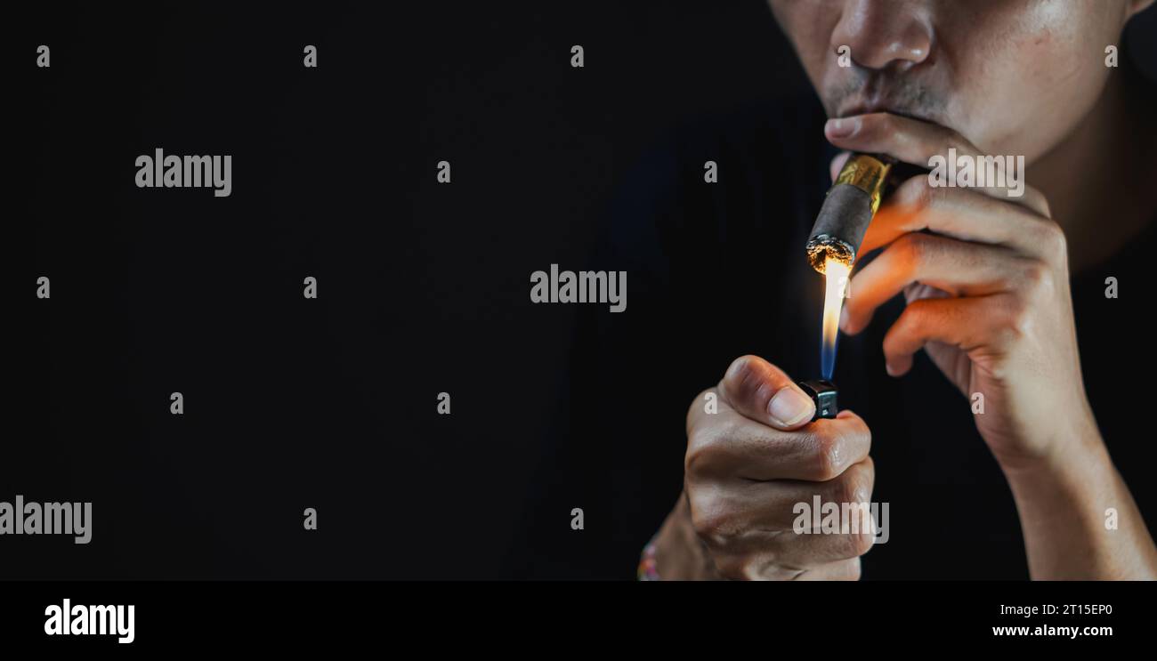 A man in dark room smoking a cigar Stock Photo - Alamy
