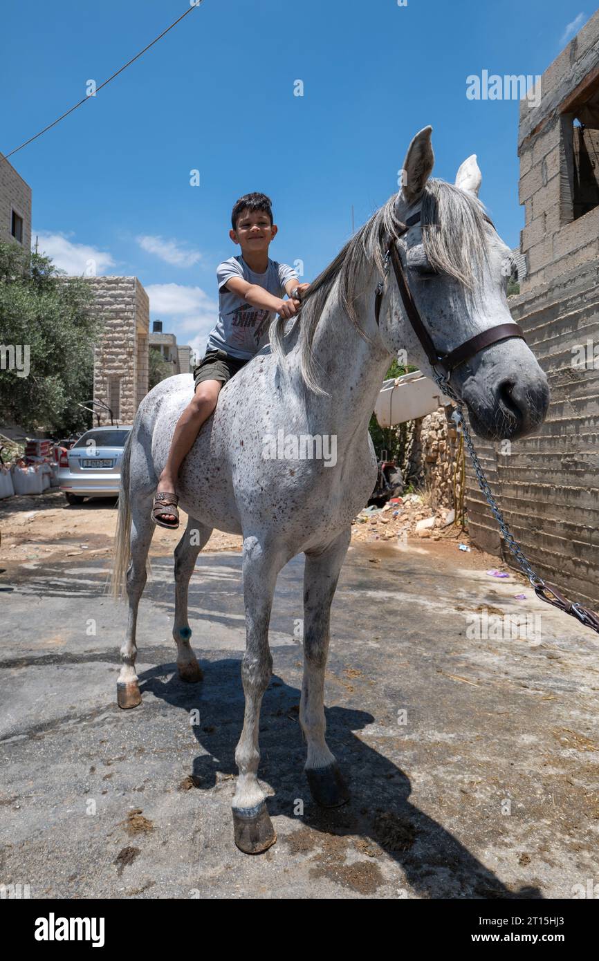 Bayt Surik, Palestine – June 19, 2023: Happy Young Arab Boy Rides a ...