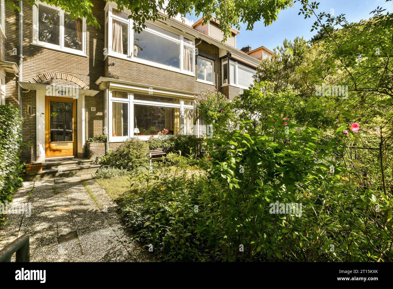 a house with trees and bushes in the front yard, as seen from the ...