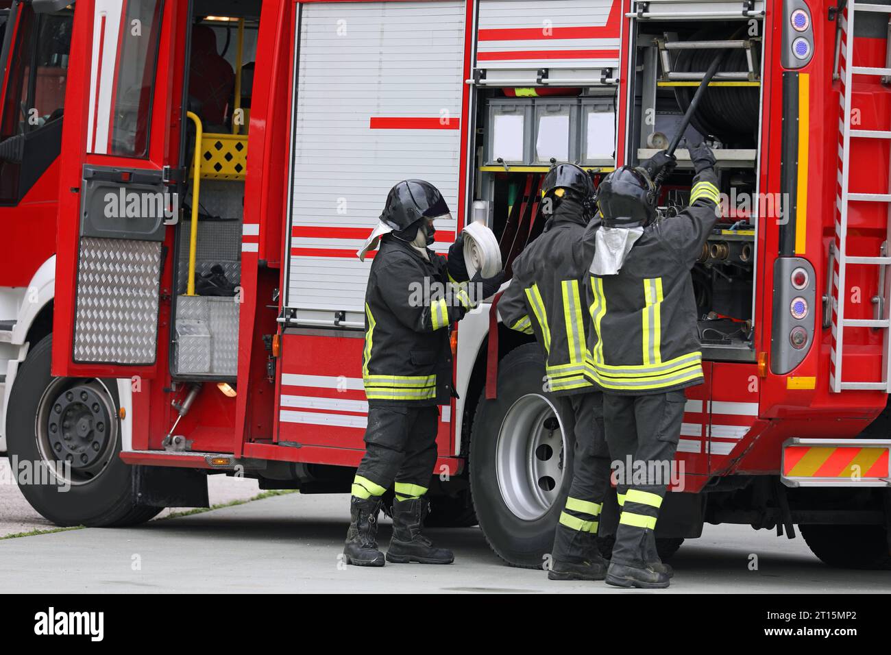 group of firefighters in action with the fire truck during the ...