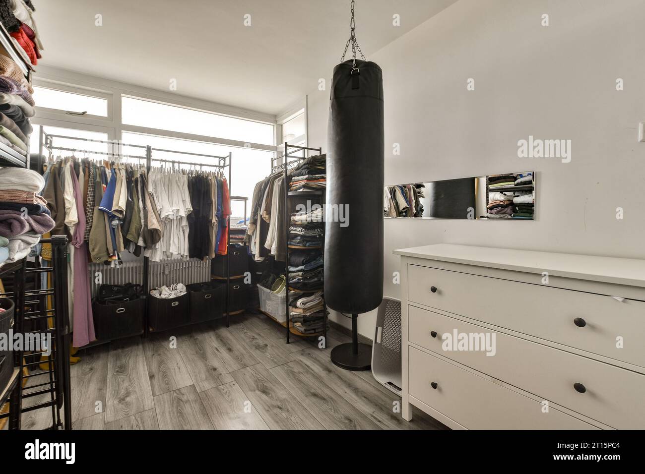 the inside of a room with clothes on hangers and a large punching bag ...