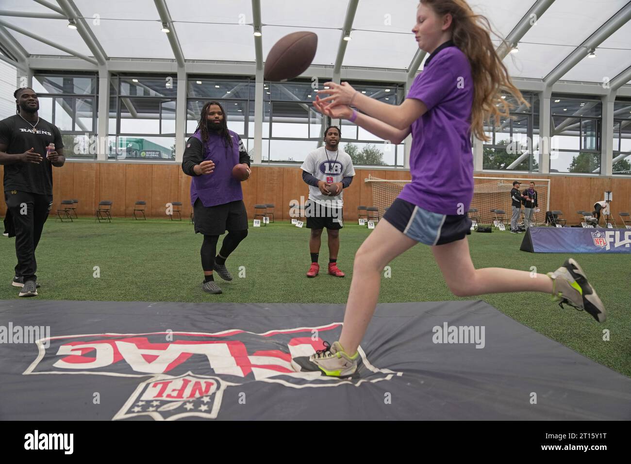 Baltimore Ravens defensive tackle Bravvion Roy, center, passes the ball ...