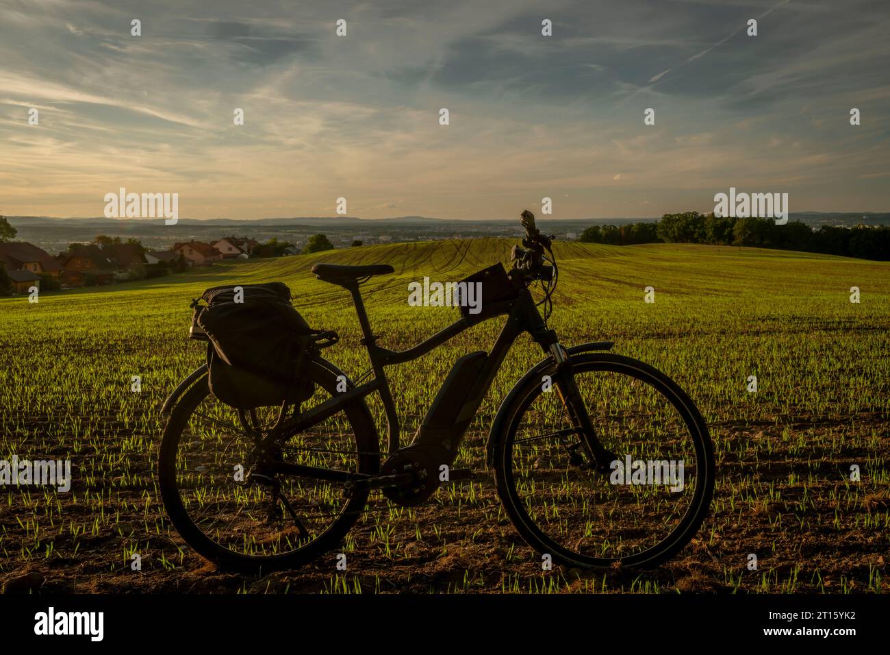 Electric black and gray bicycle on green field with sunset colors near ...