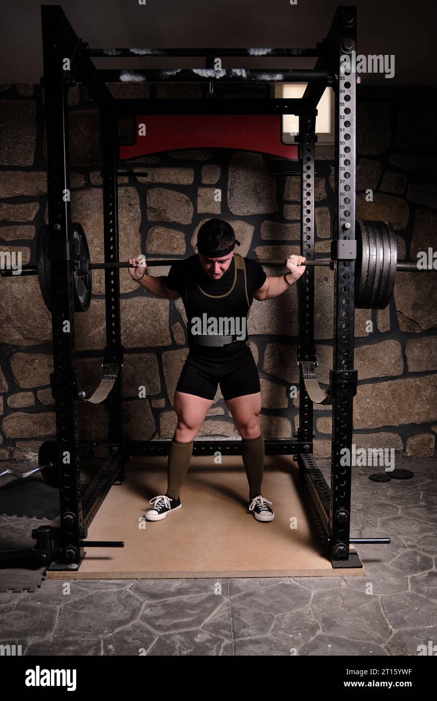Strong sportsman lifting barbell on back in gym Stock Photo - Alamy