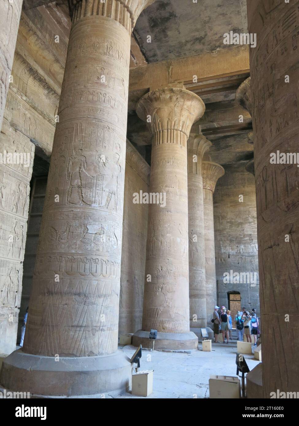 Tourists are dwarfed by the tall columns covered in reliefs from the ...