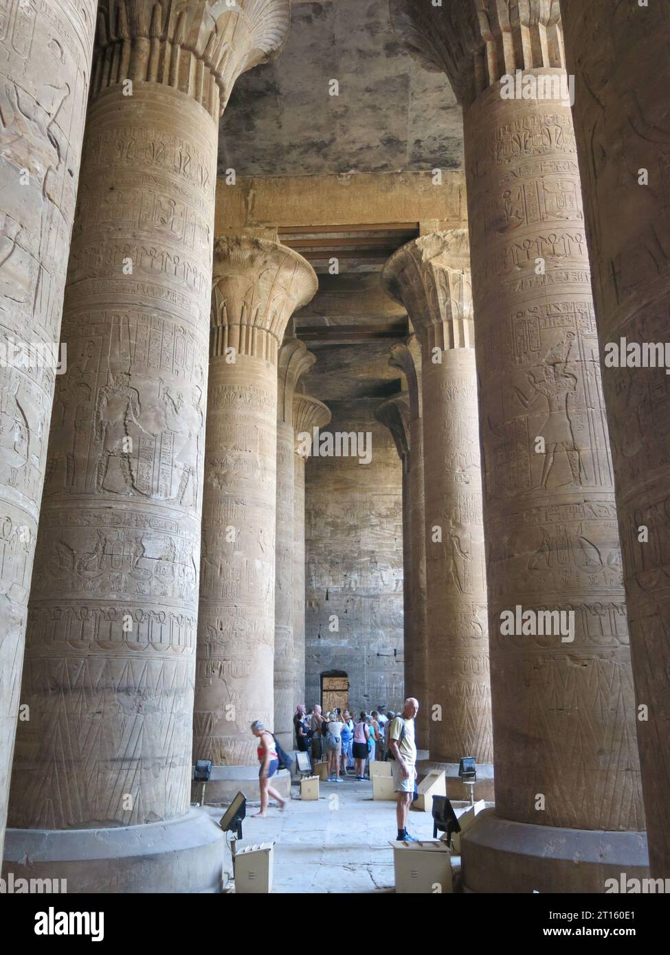 Tourists are dwarfed by the tall columns covered in reliefs from the ...