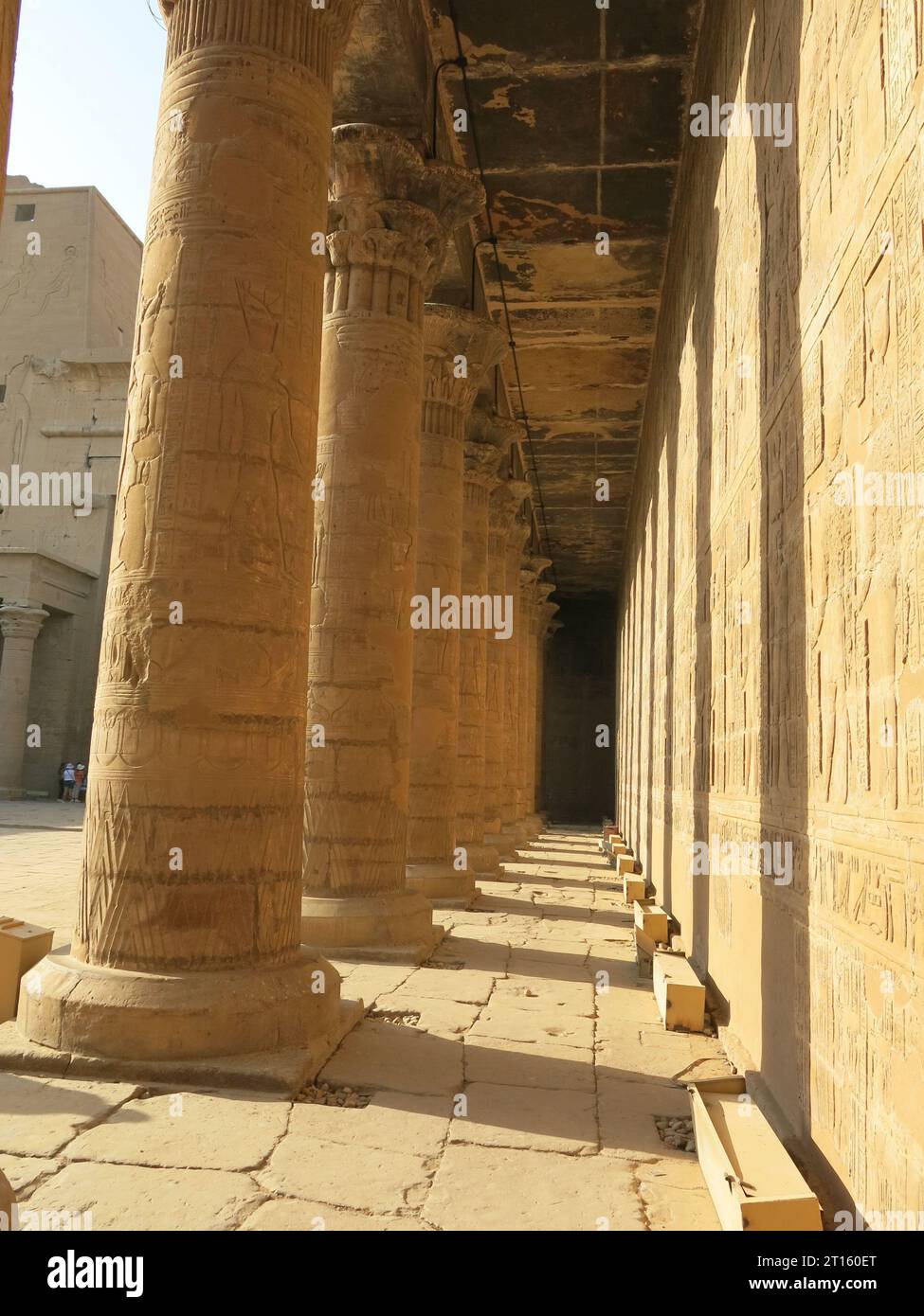 View of the tall sandstone pillars in front of a wall of the courtyard ...