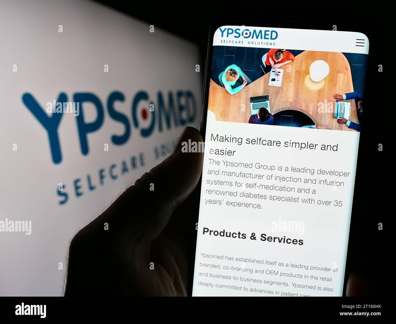 Person holding cellphone with webpage of Swiss medical technology ...