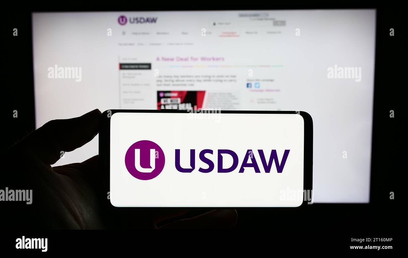 Person holding cellphone with logo of Union of Shop Distributive and ...