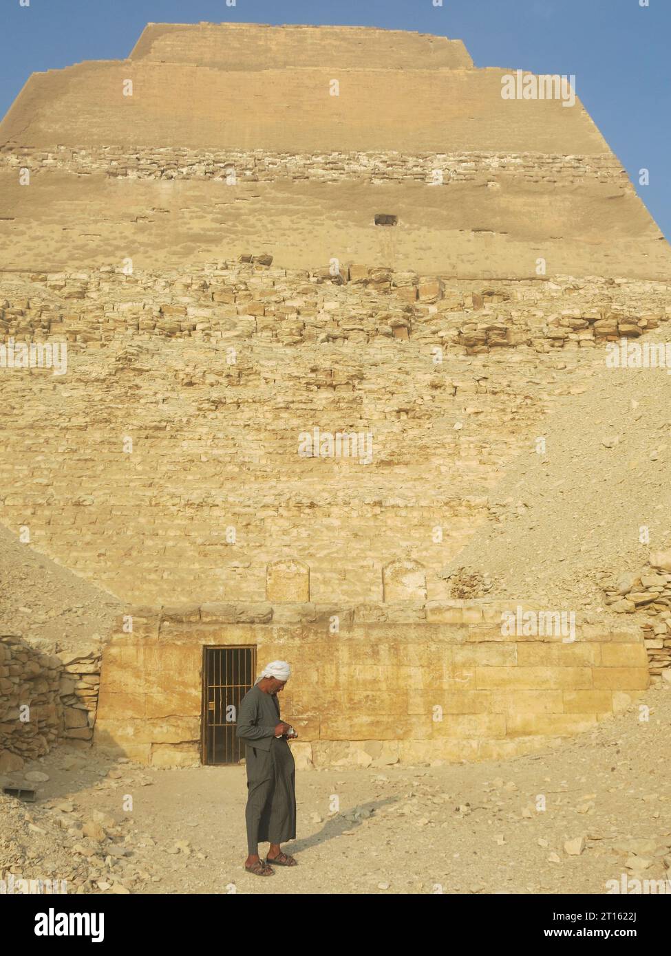 Man in Egyptian dress (gallibaya) outside the 70m high Meidum Pyramid ...