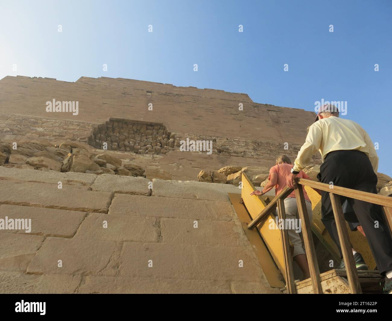 Tourists climb the steps to half-way up the side of the Meidum Pyramid ...