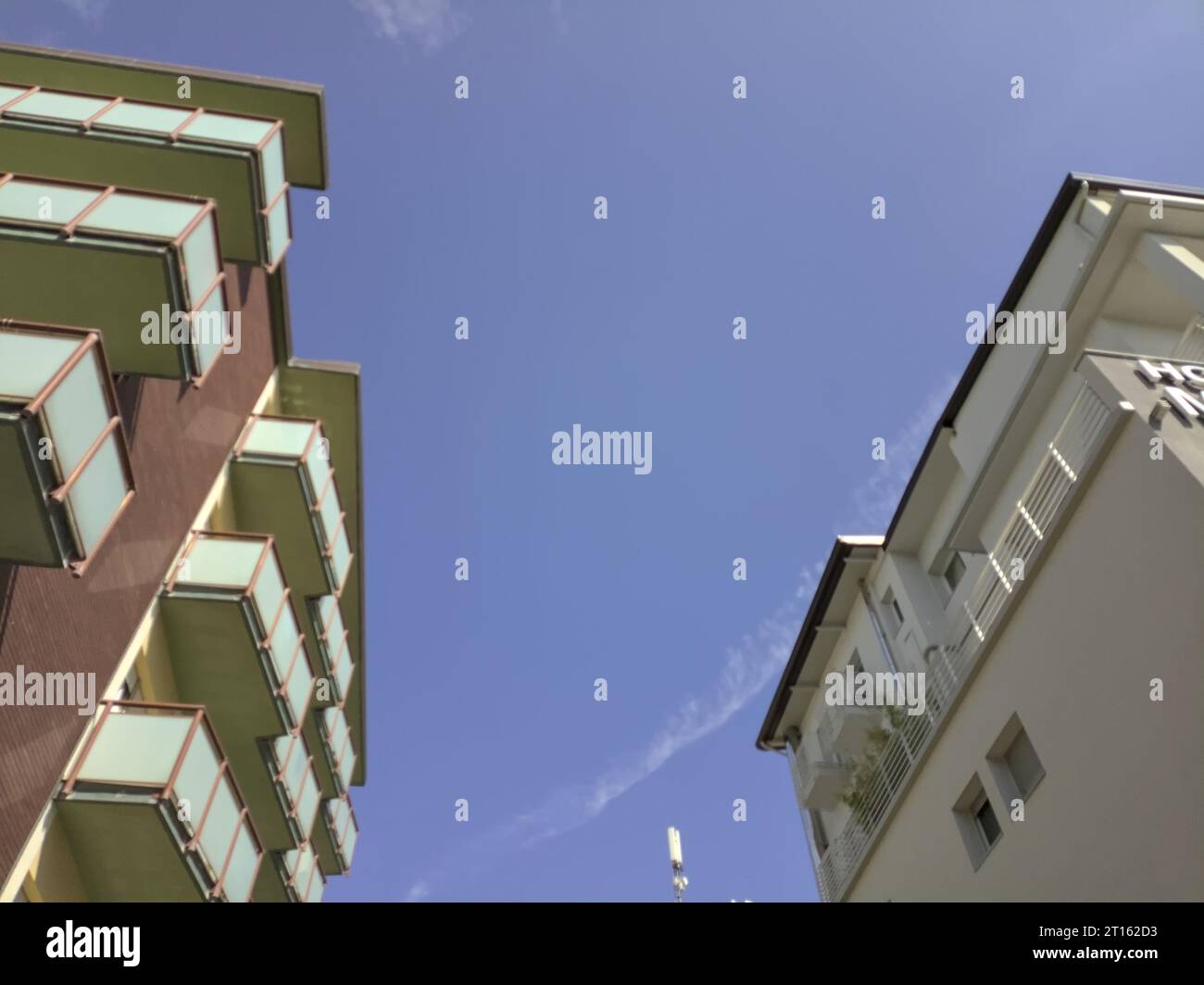 Two buildings side by side with balconies by their sides on a sunny day ...