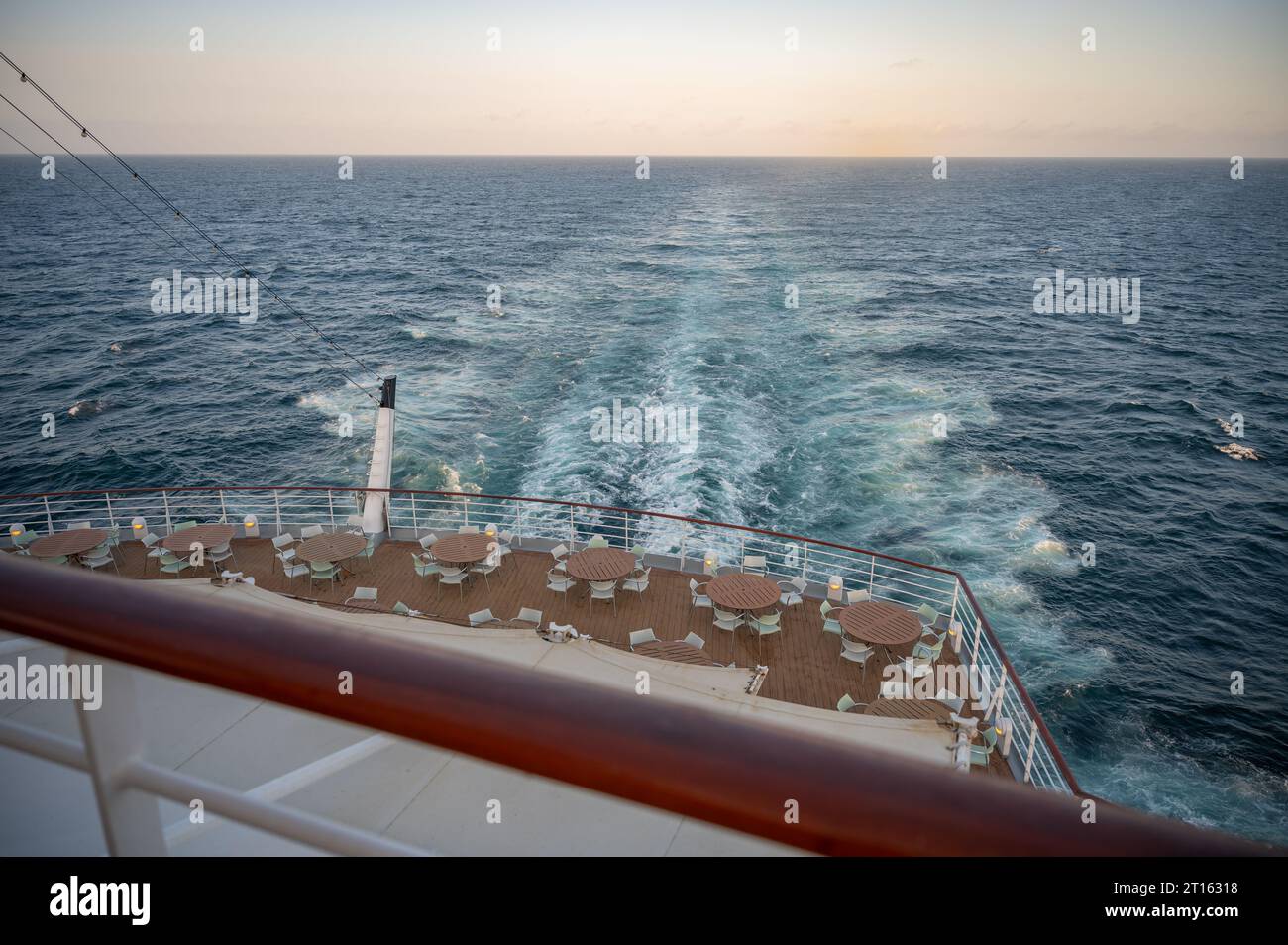 Round tables and chairs standing on boat deck at the back side of a ...