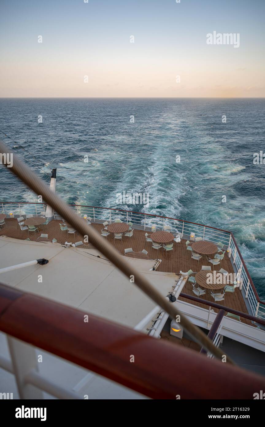Round tables and chairs standing on boat deck at the back side of a ...