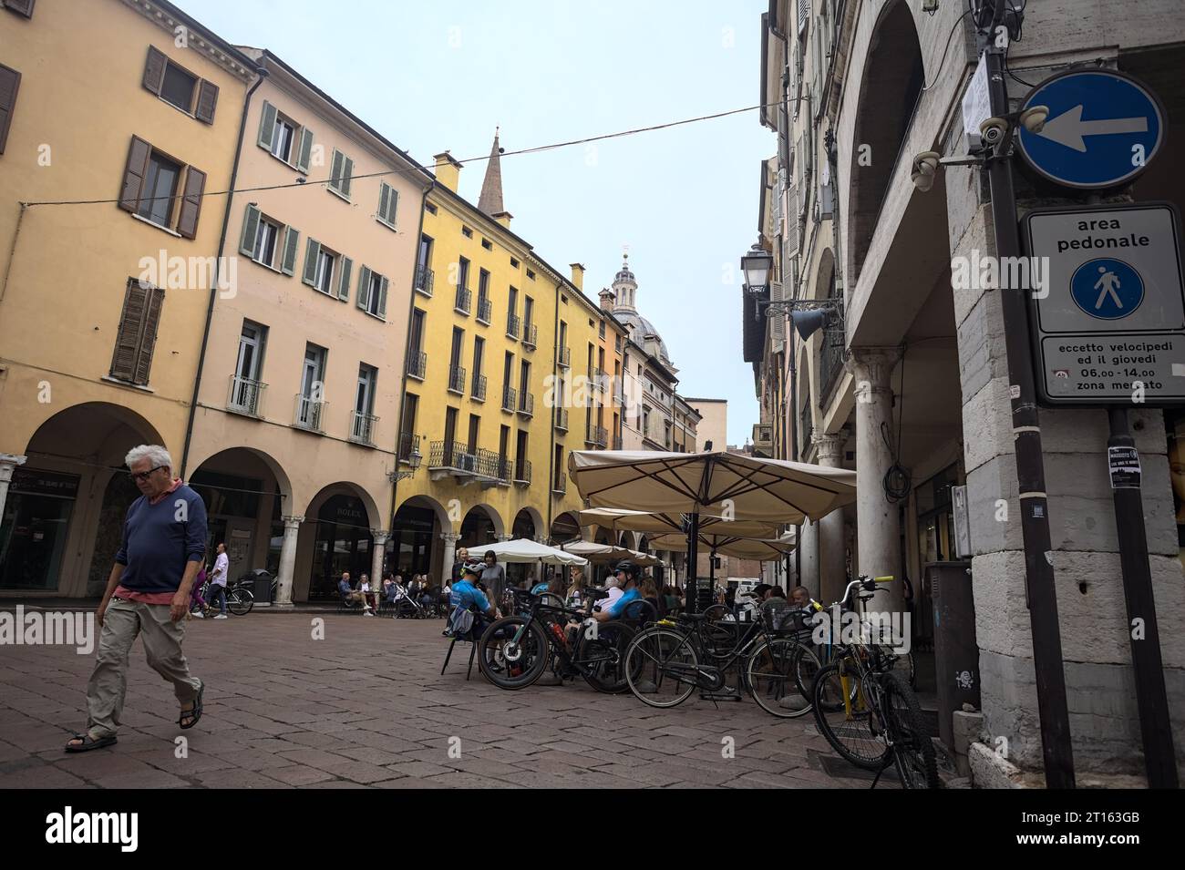 Cobbled square bordered by buildings with porchways in an italian town ...