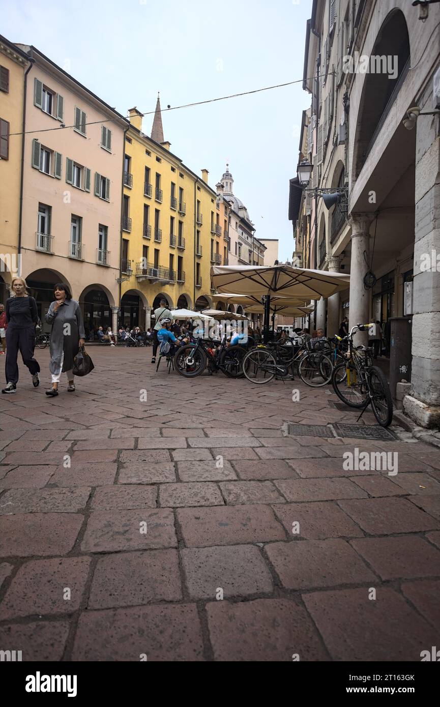 Cobbled square bordered by buildings with porchways in an italian town ...