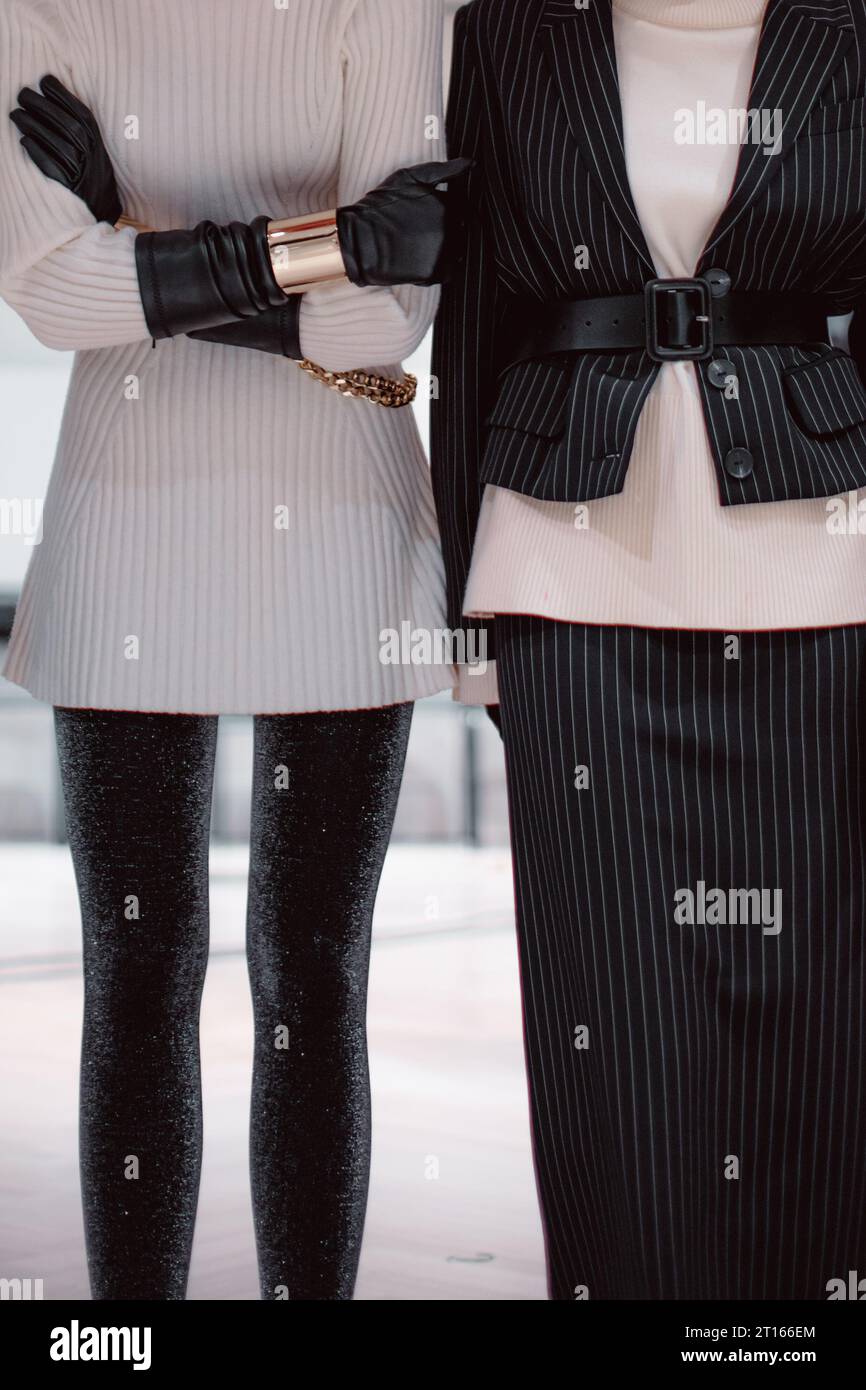 Fancy details of a knitted warm white sweater, black leather gloves ...