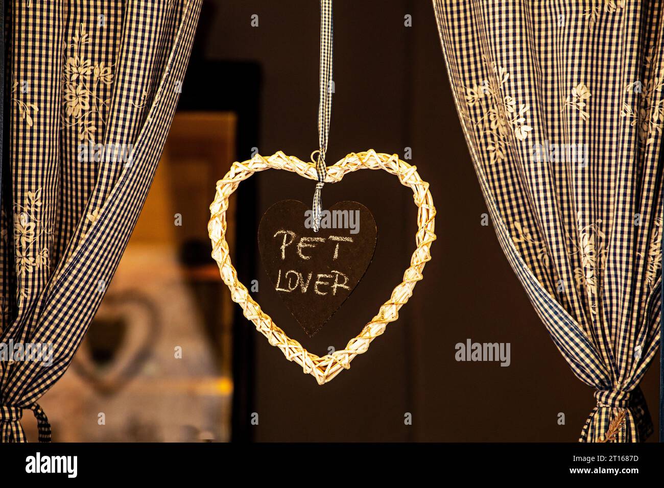 cute wicker heart with a sign about love for animals on the window ...