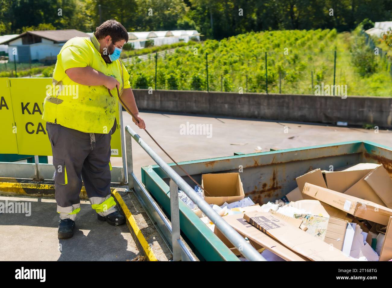 Worker in a recycling factory or clean point and garbage with a face ...