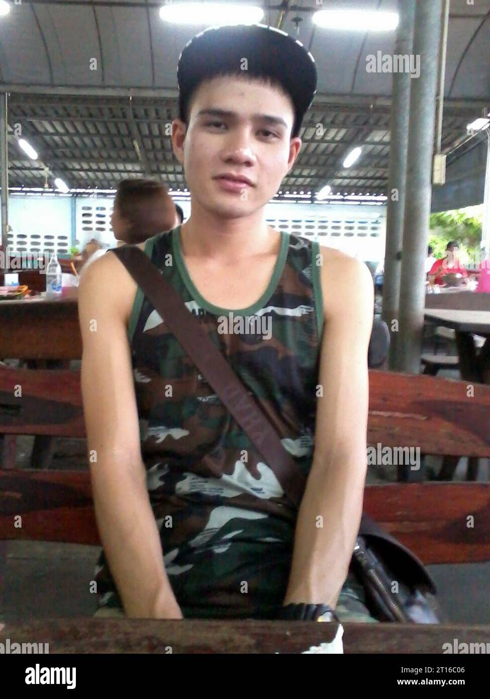 handsome young thai man poses for photo, looking at camera wears vest ...