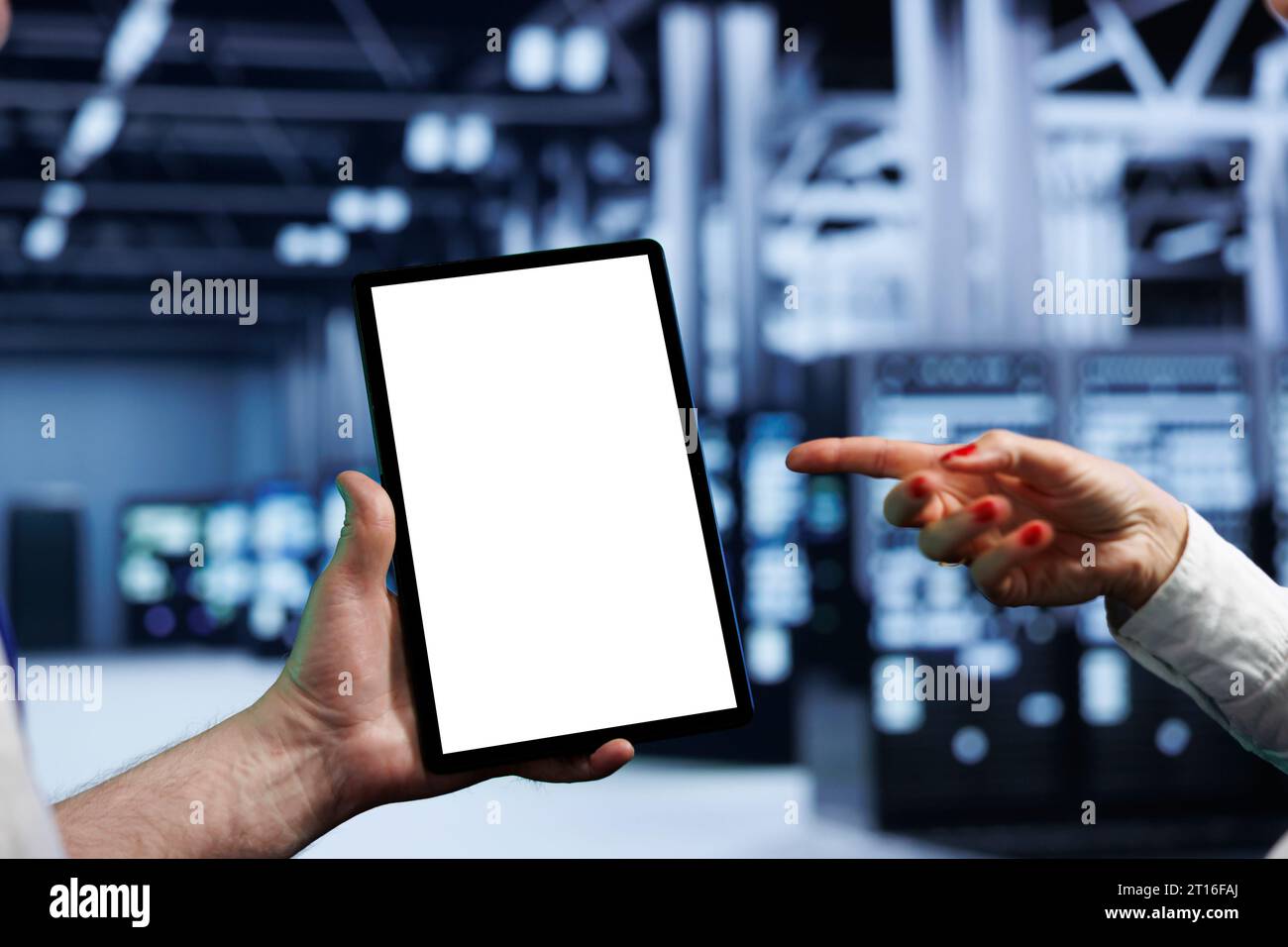 Elderly programmers in high tech workspace using mock up tablet to set ...
