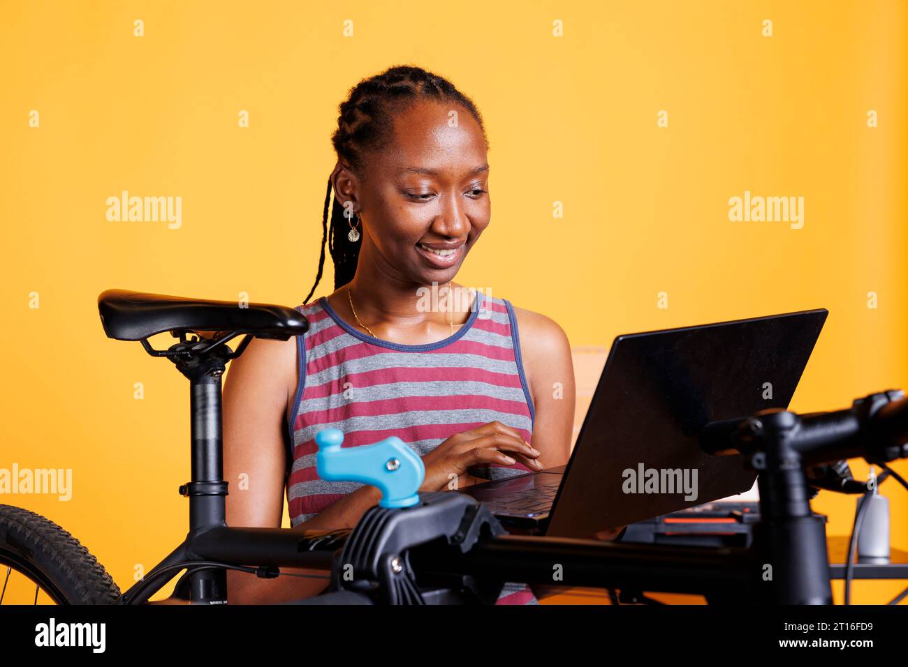 Dedicated african american female cyclist using laptop for research on ...