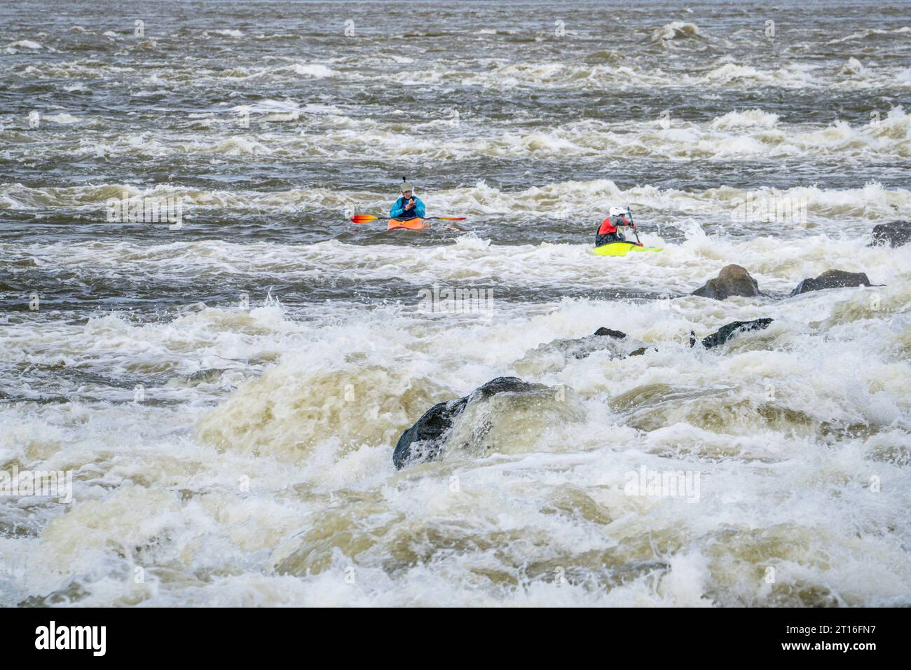 two whitewater kayakers playing and training below Low Water Dam on the ...