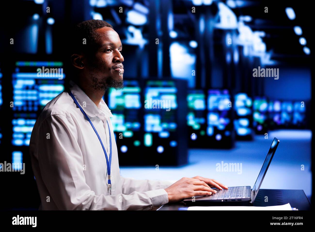 African american IT programmer in high tech facility using laptop to ...