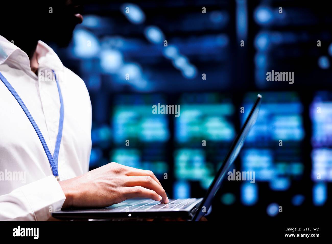 Employee using laptop to do checkup on supercomputers with high ...