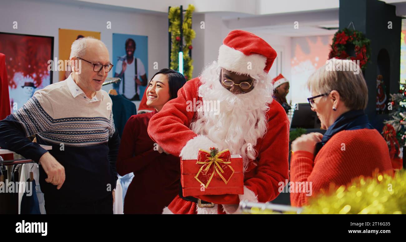 Worker wearing Santa Claus suit holding present box acting as raffle ...