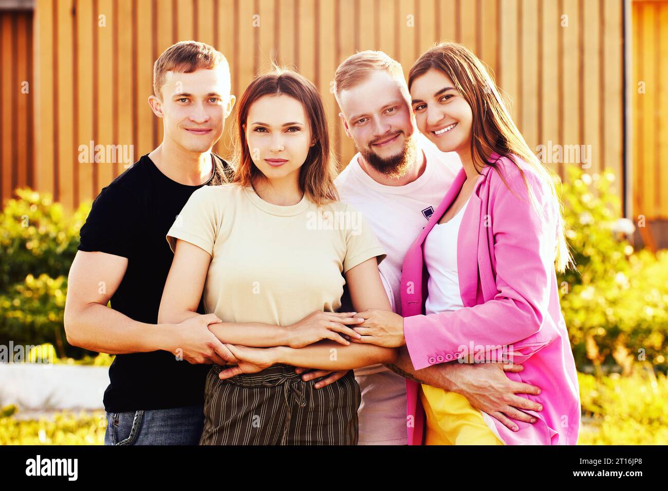 Four young people, two married couples are photographed outdoors in ...