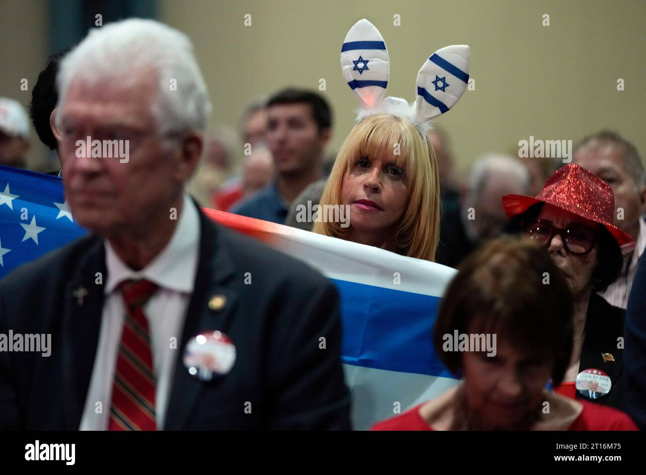 An attendee wears ears in the pattern of the Israeli flag, at an event ...