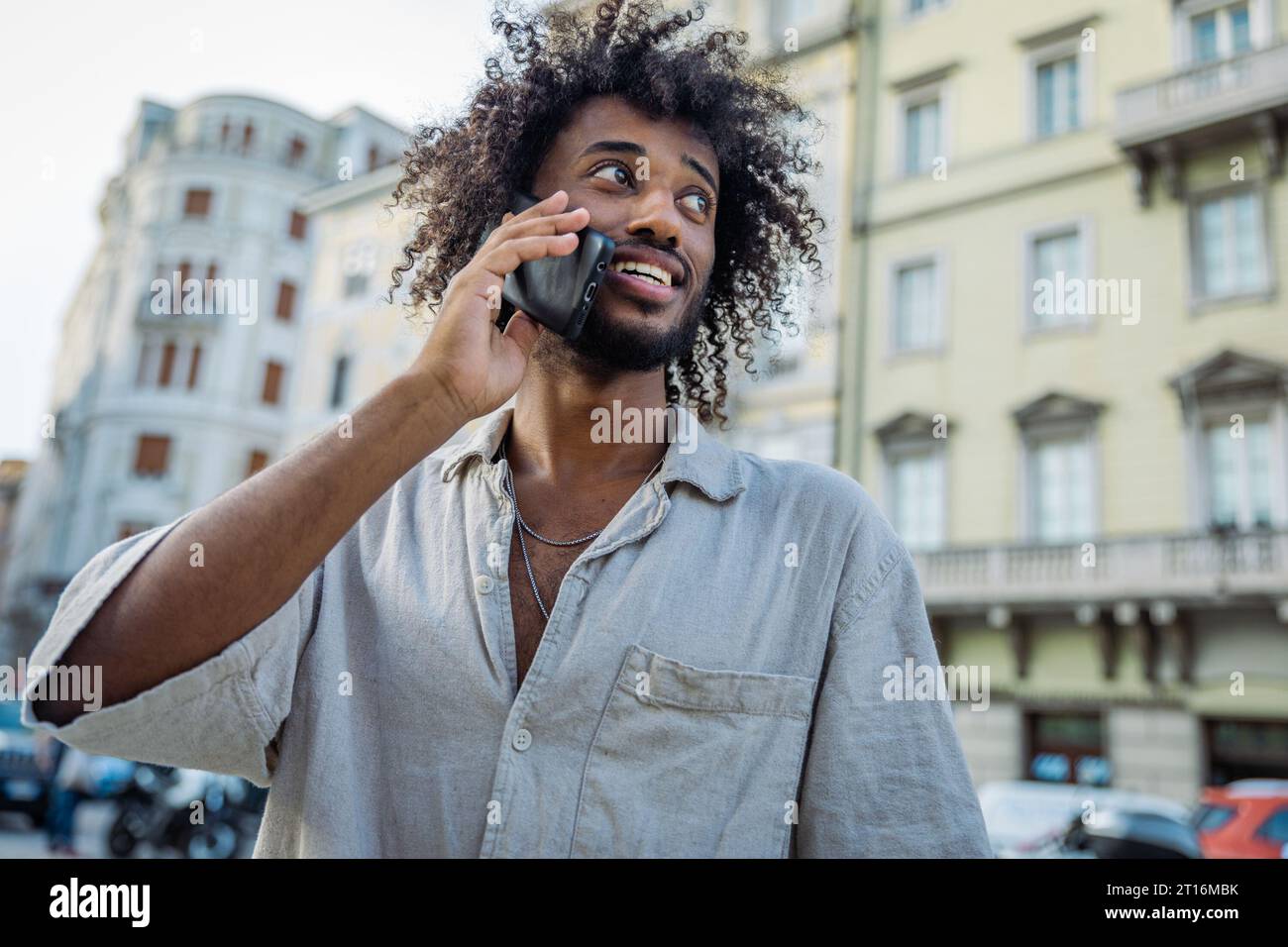 Portrait of a young attractive east African man making a phone call ...