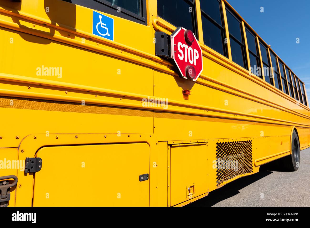 A big red stop sign on the side of a yellow school bus Stock Photo - Alamy