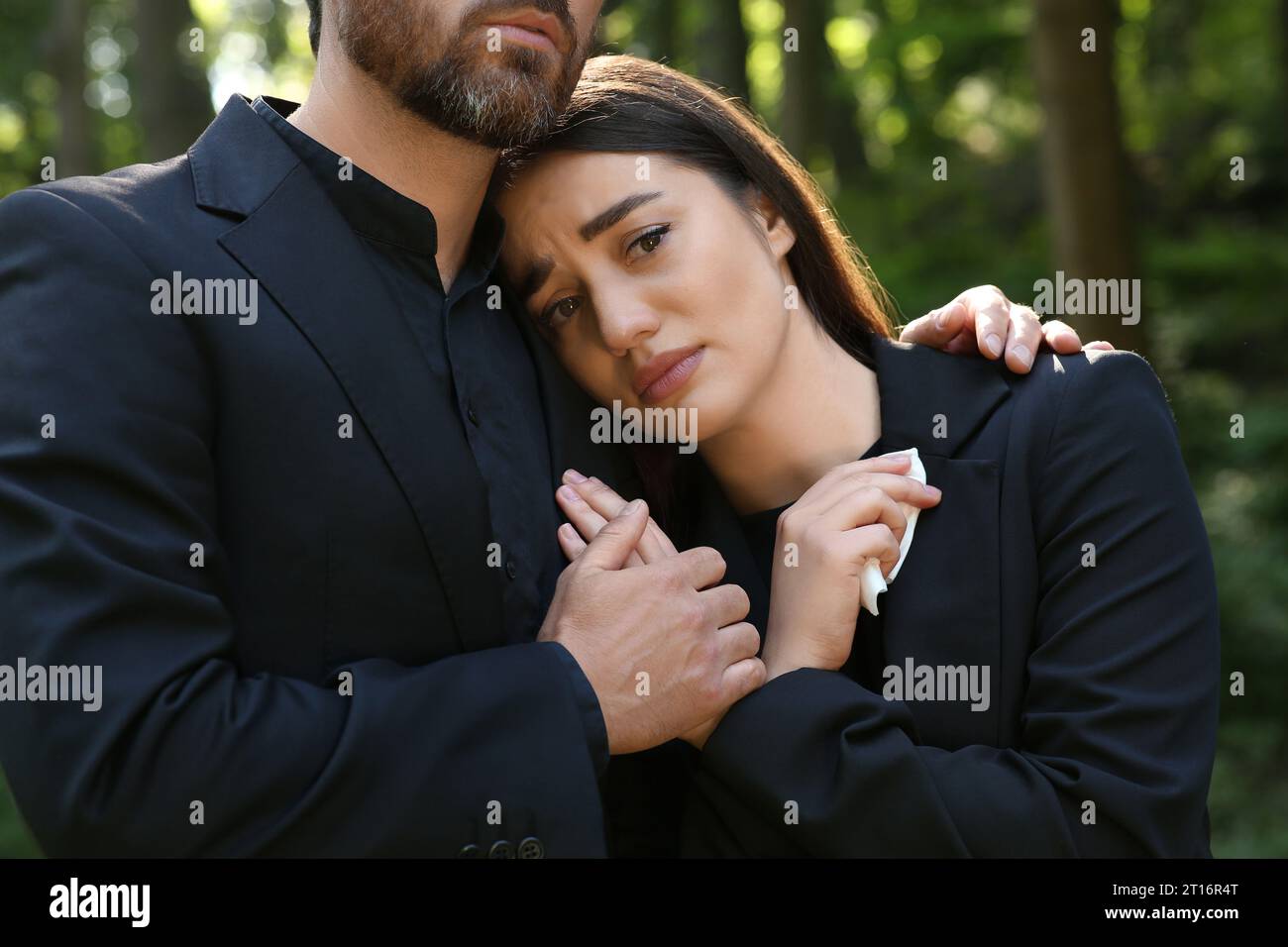 Sad couple in black clothes mourning outdoors. Funeral ceremony Stock ...