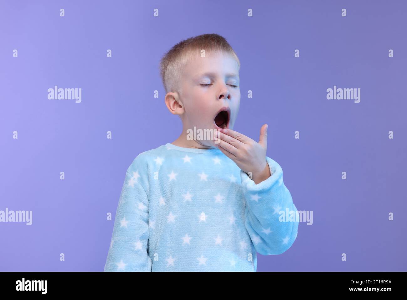Sleepy boy yawning on purple background. Insomnia problem Stock Photo ...