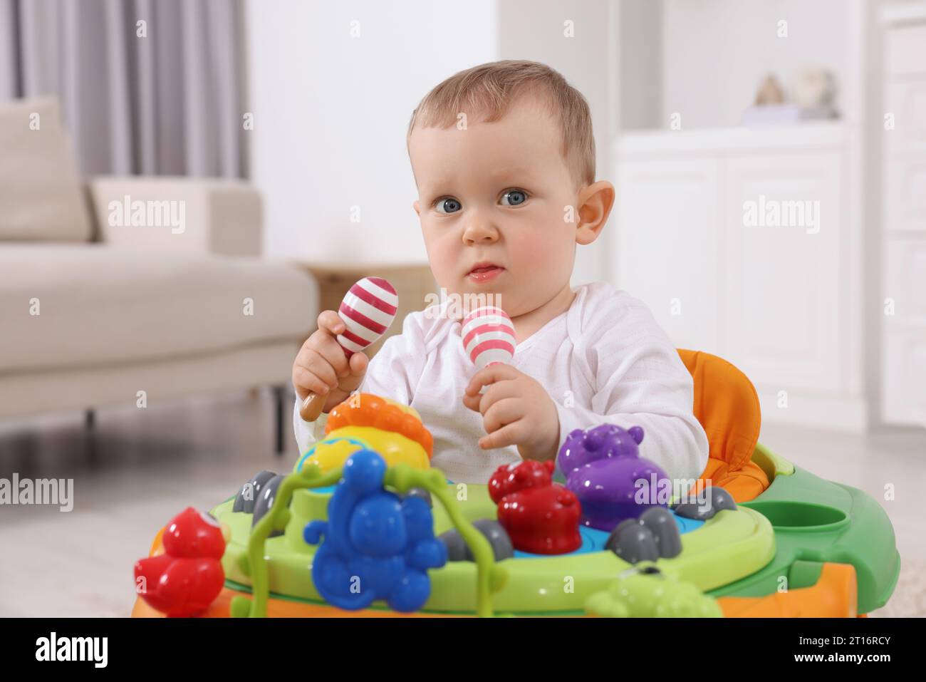 Portrait of cute baby with toy walker at home. Learning to walk Stock ...