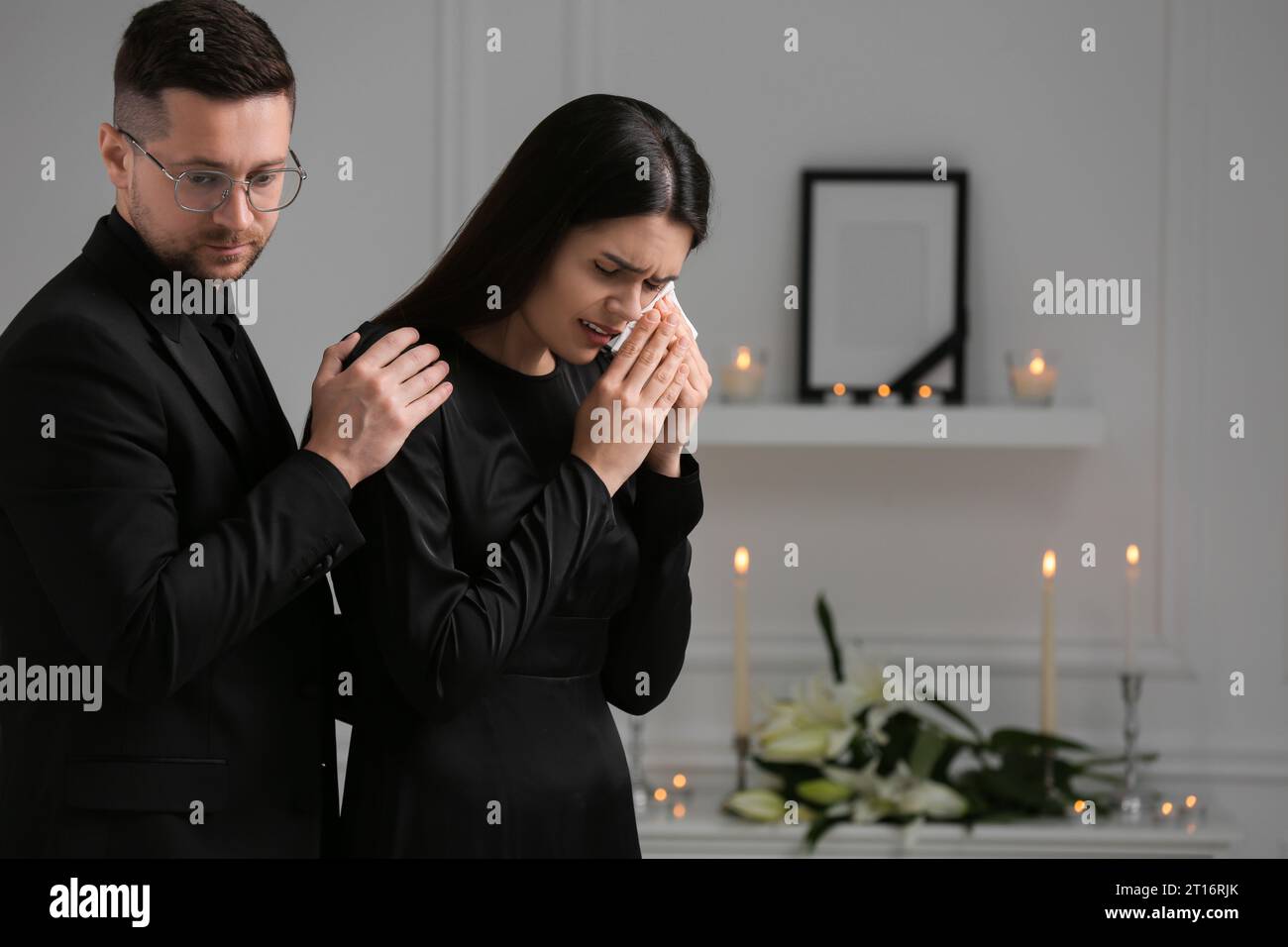 Sad couple mourning indoors, space for text. Funeral ceremony Stock ...