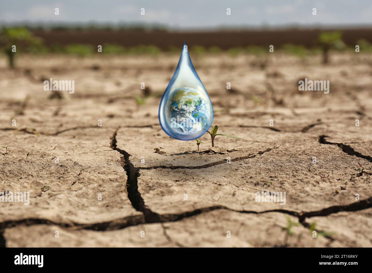 Save environment. Drop with Earth falling on dry cracked land, closeup ...