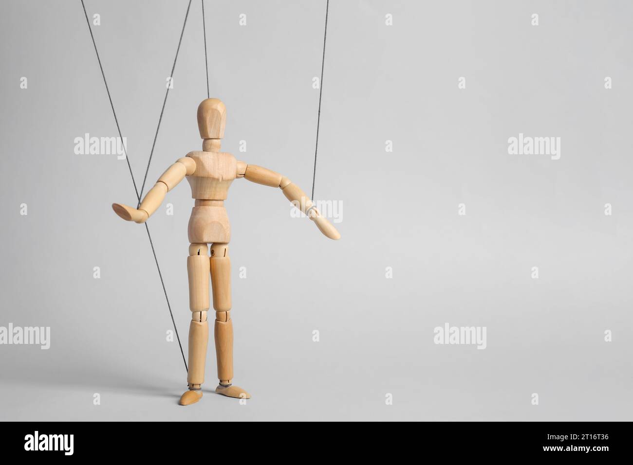 One wooden puppet with strings on light grey background. Space for text Stock Photo - Alamy