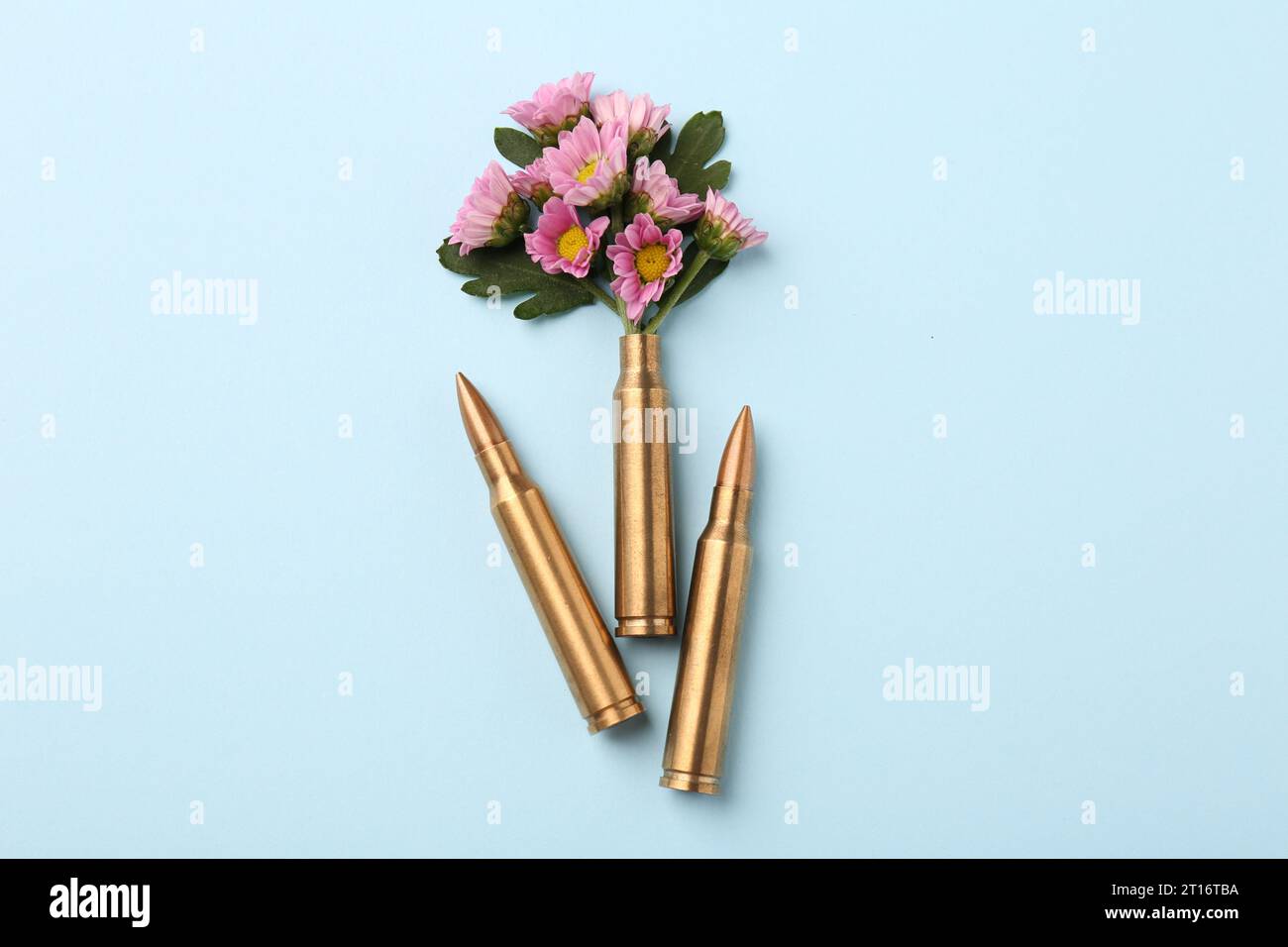 Bullets and cartridge case with beautiful flowers on light blue ...